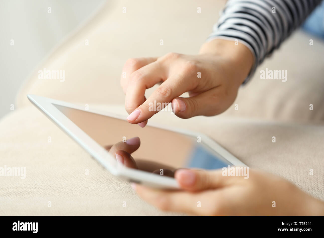 Female hand holding PC tablet on home interior background Stock Photo ...