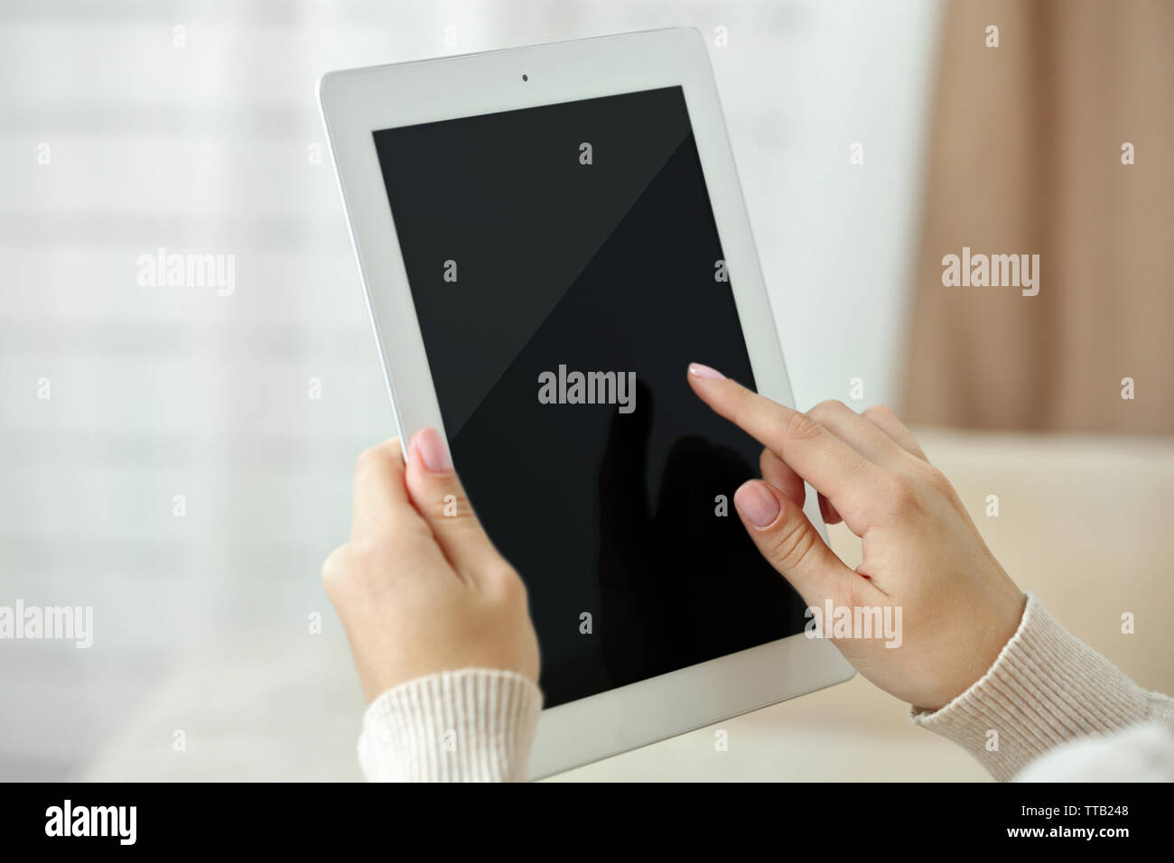 Female hand holding PC tablet on home interior background Stock Photo ...