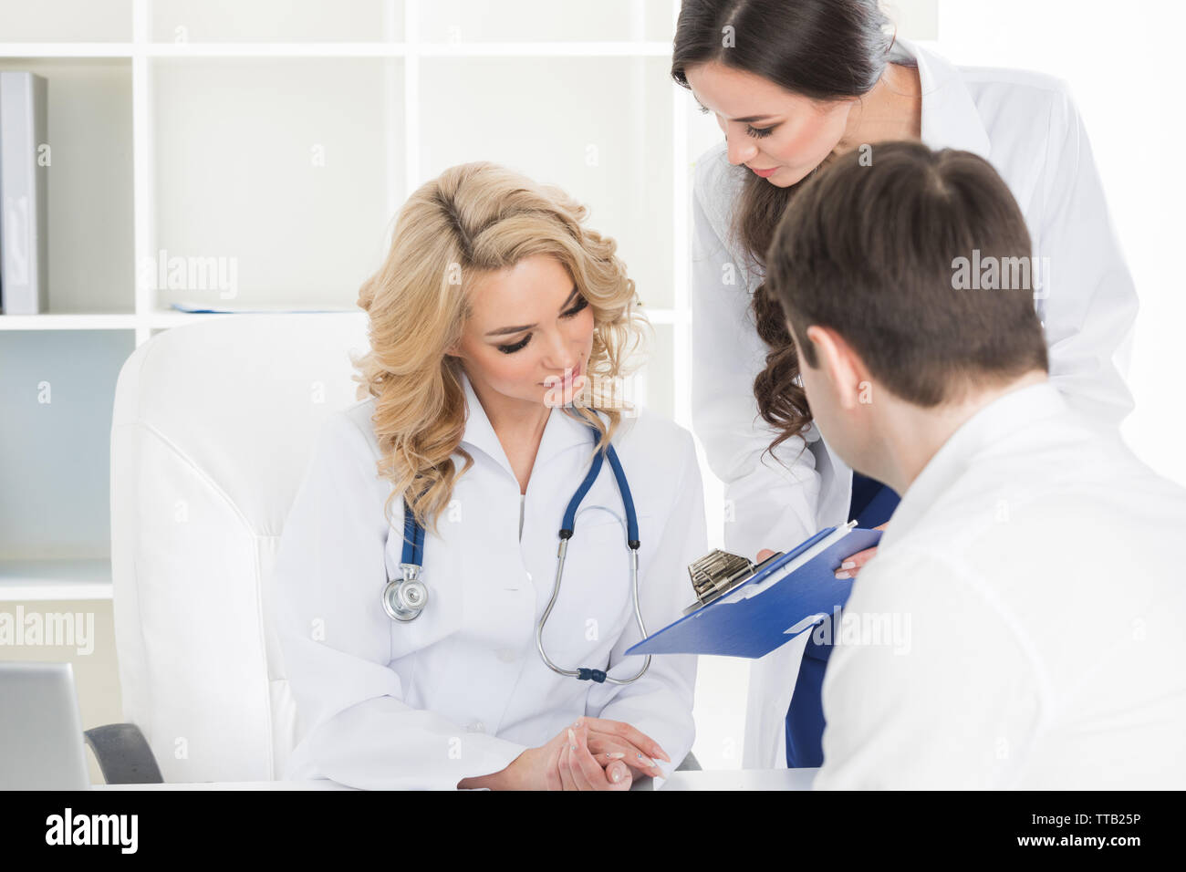 Doctors consulting patient in a clinical office Stock Photo - Alamy