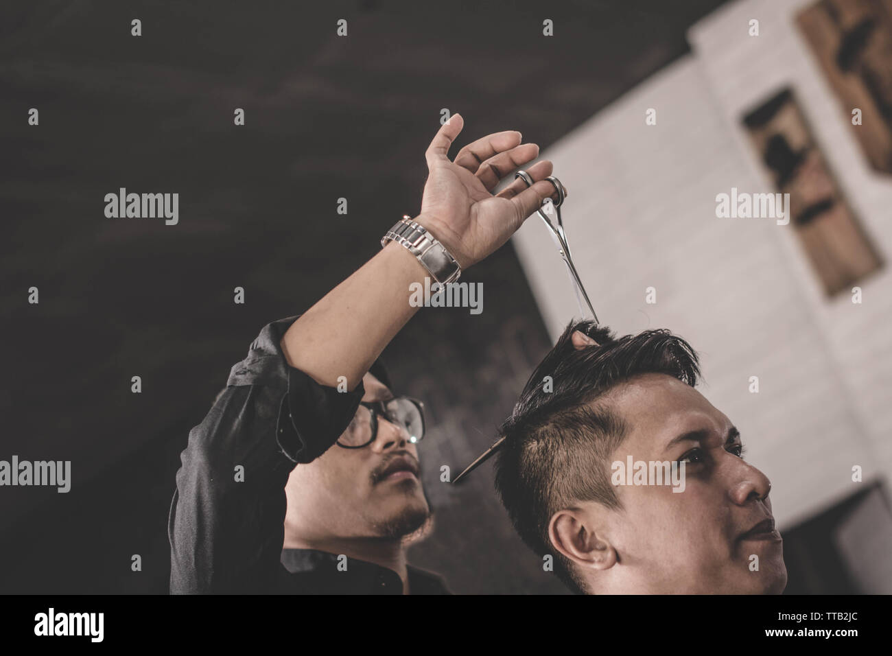 close up portrait of professional barber making hair cut of his ...