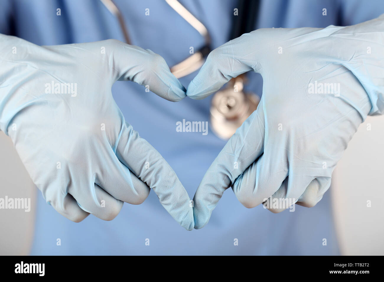 Doctor hands in gloves making shape of heart, closeup Stock Photo - Alamy