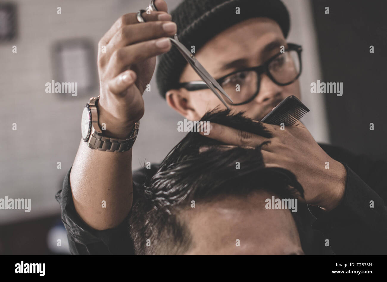 close up portrait of professional barber making hair cut of his ...