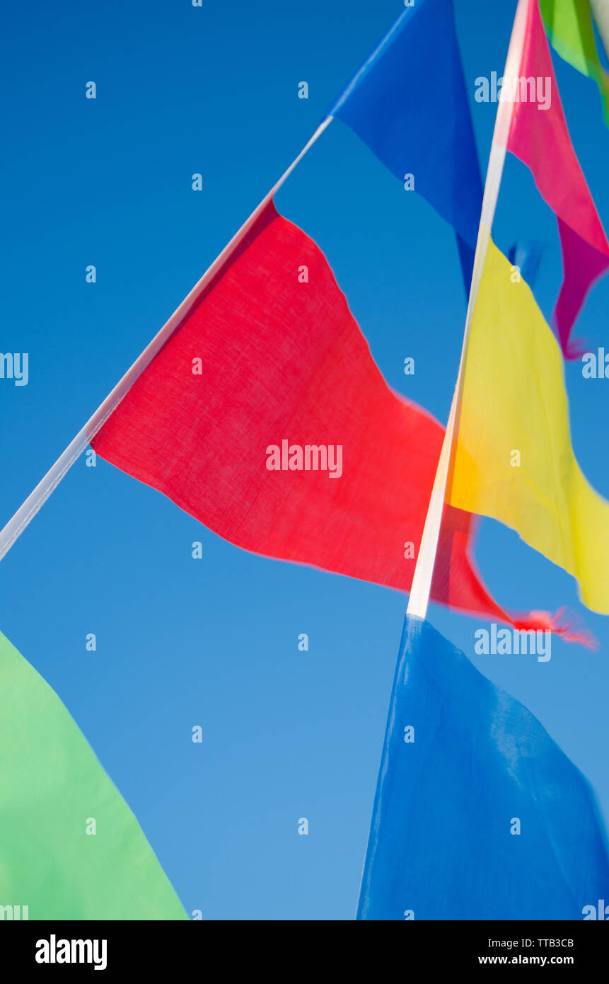 Dangling in the wind festive flags on the background of blue sky Stock ...