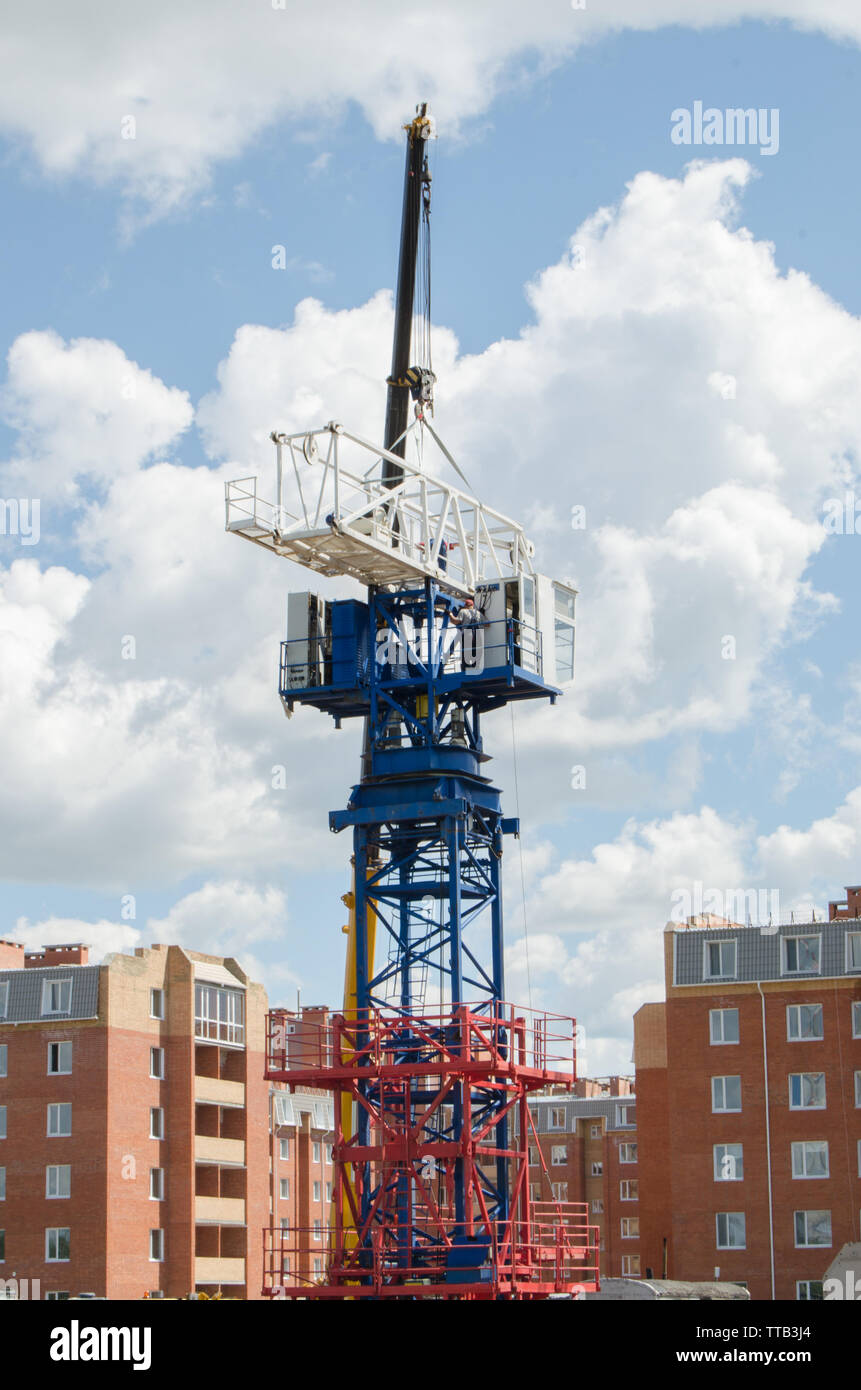 The assembly of the high crane. The crane lift raises part of the boom ...