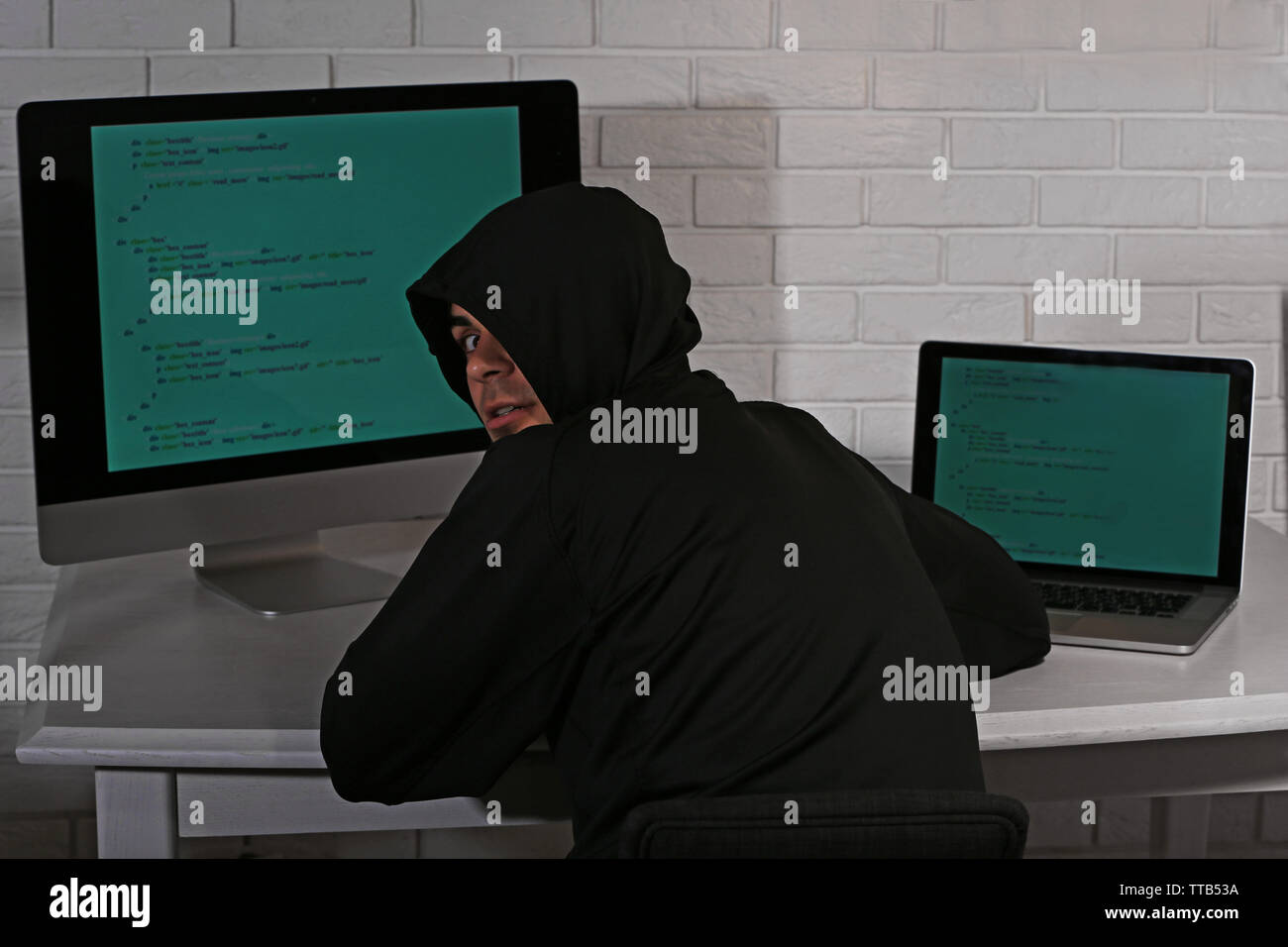 Hacker with computer and laptop Stock Photo - Alamy