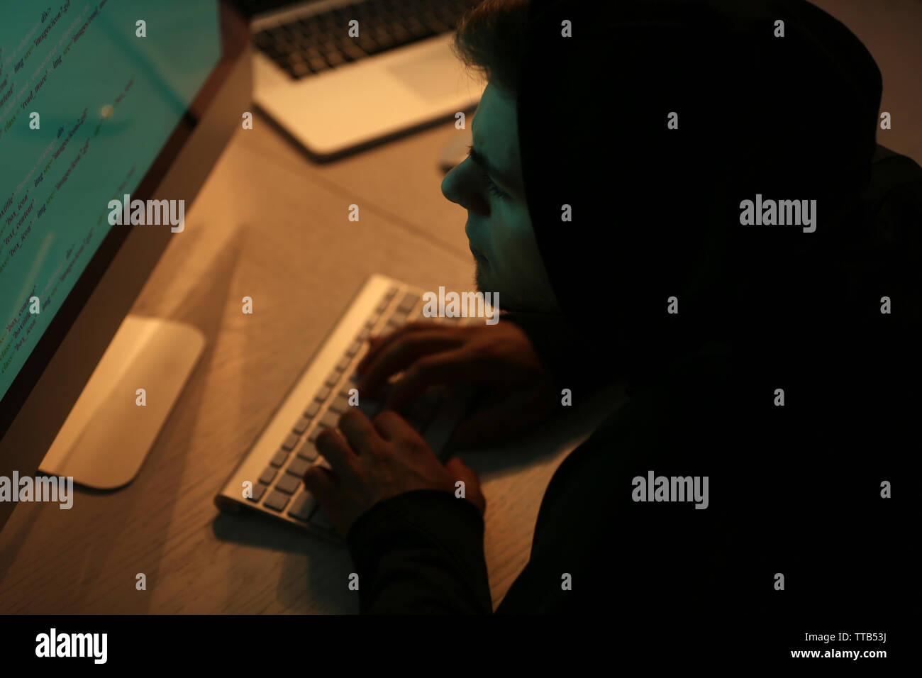 Hacker with computer and laptop Stock Photo - Alamy