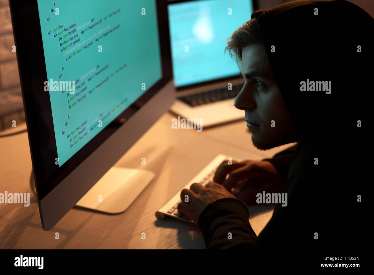 Hacker with computer and laptop Stock Photo - Alamy