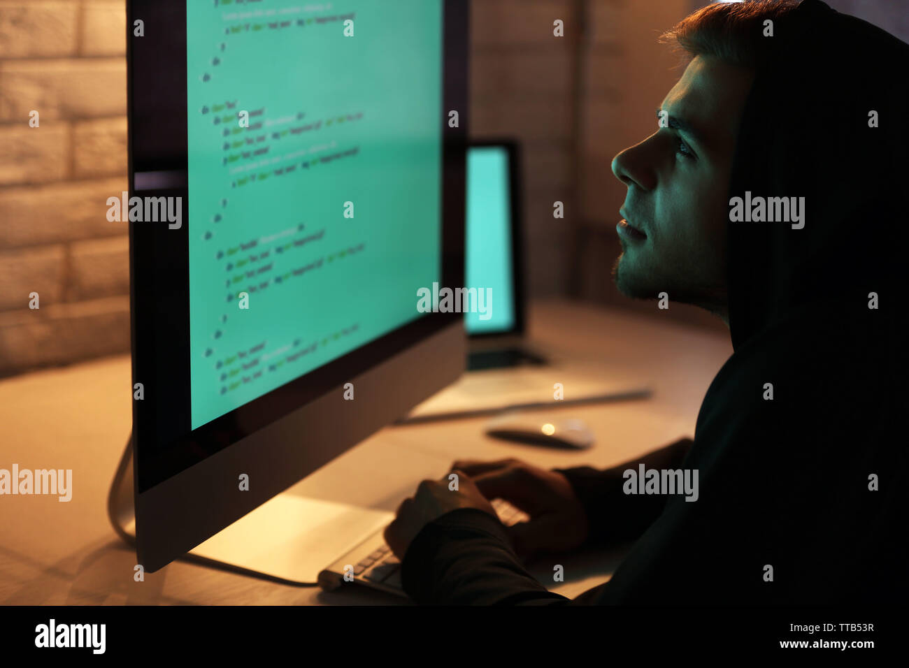 Hacker with computer and laptop Stock Photo - Alamy
