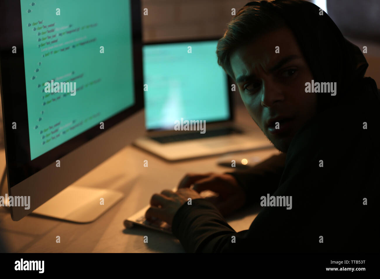 Hacker with computer and laptop Stock Photo - Alamy