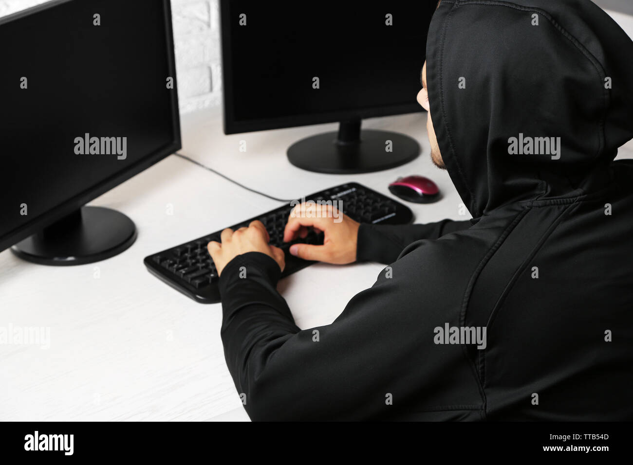 Hacker with computers in room Stock Photo - Alamy