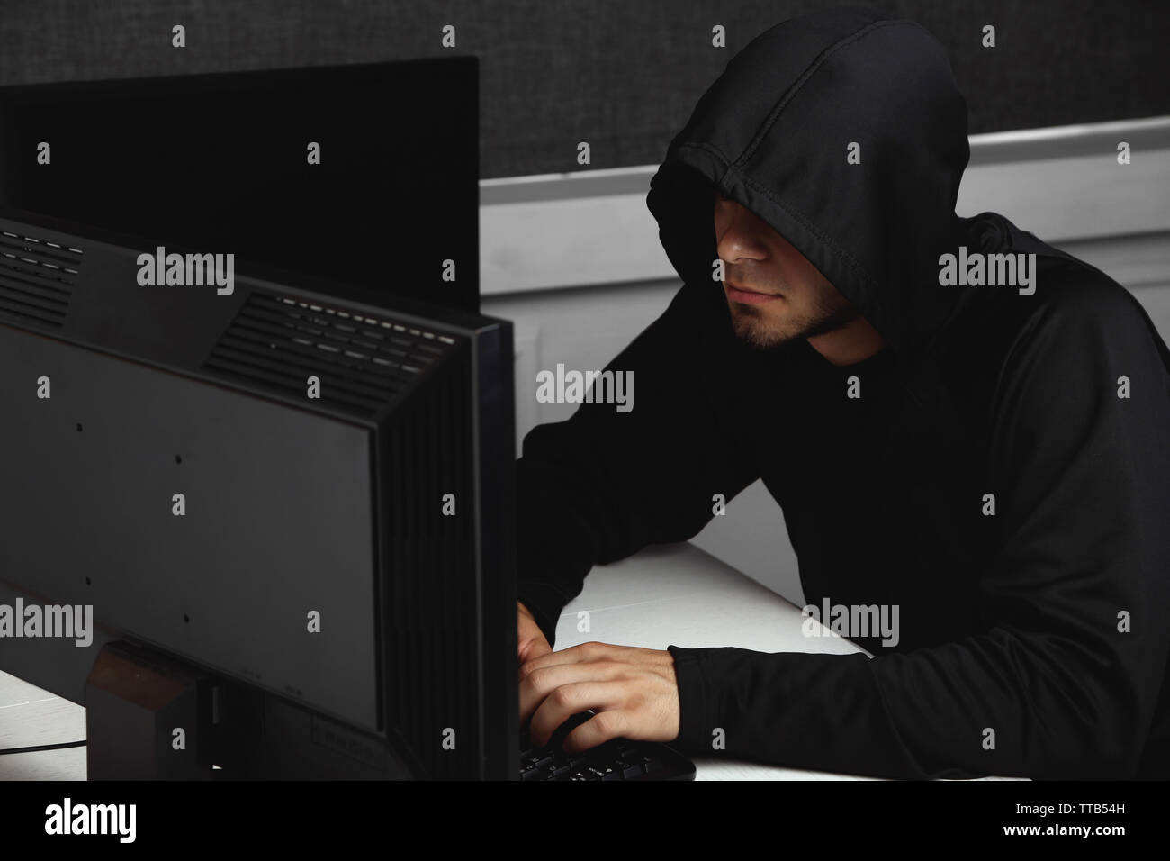 Hacker with computers in room Stock Photo - Alamy