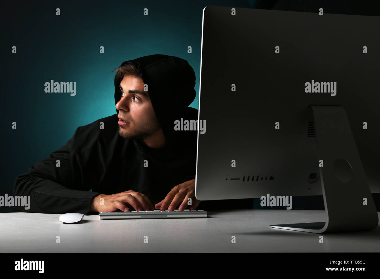 Hacker with computer on colorful dark background Stock Photo - Alamy