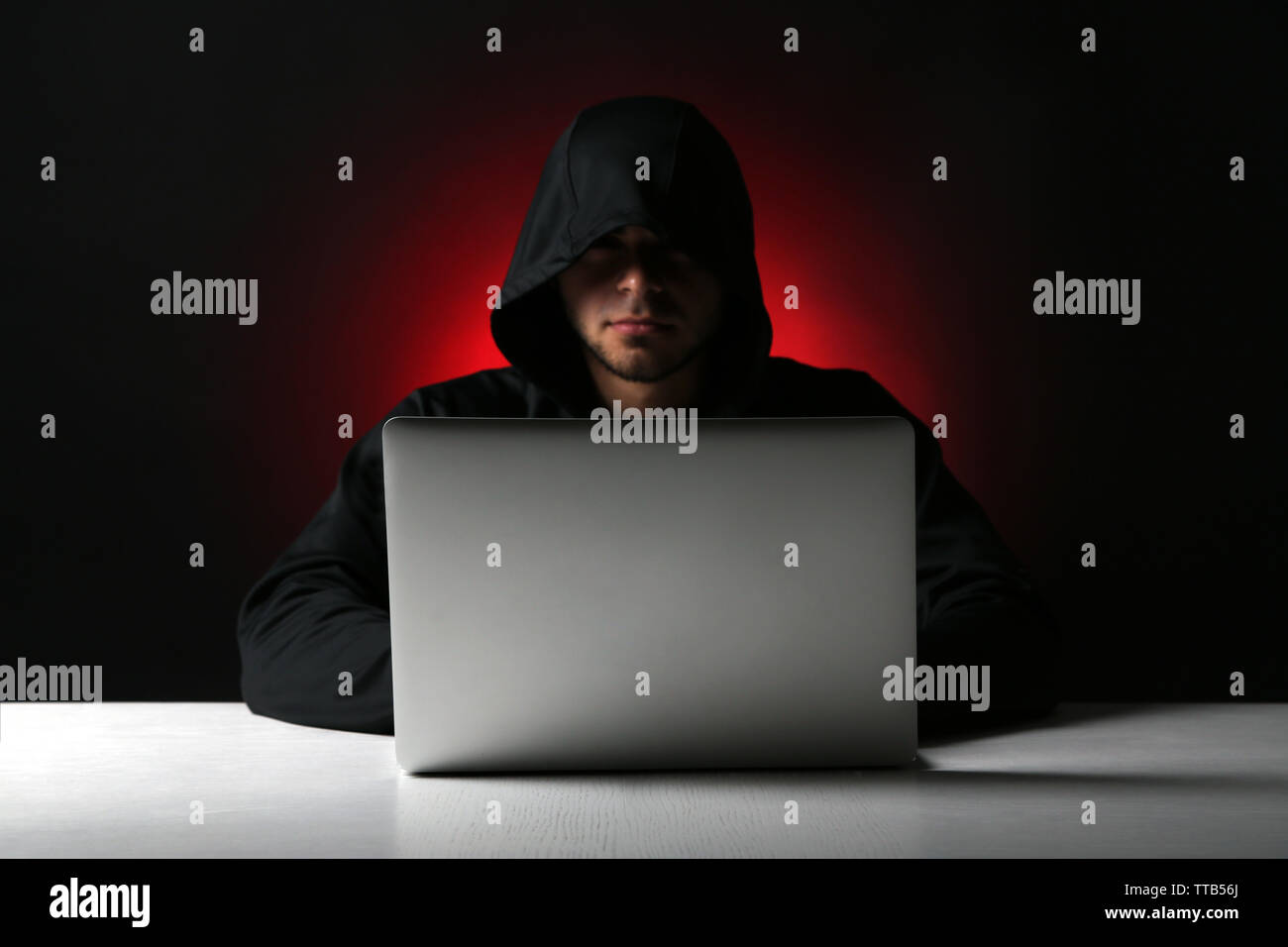 Hacker with computer and laptop on colorful dark background Stock Photo ...