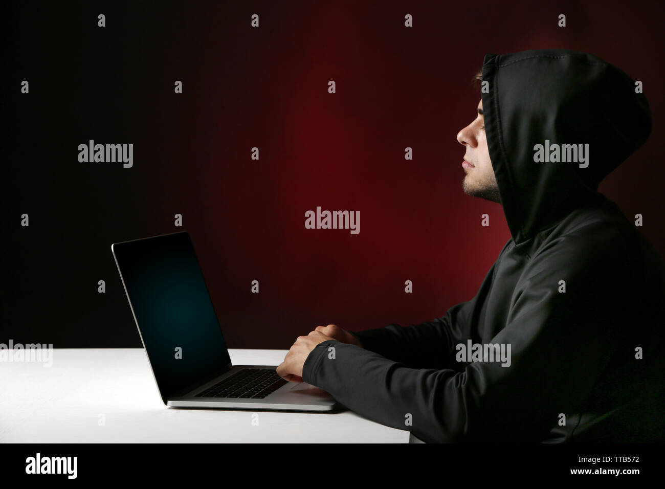 Hacker with computer and laptop on colorful dark background Stock Photo ...