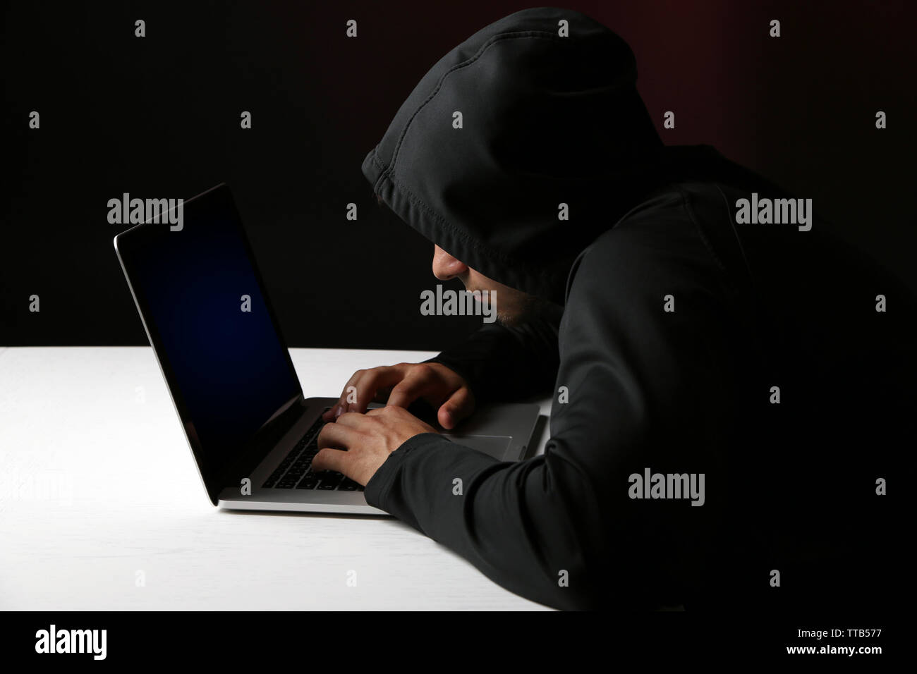 Hacker with computer and laptop on colorful dark background Stock Photo ...