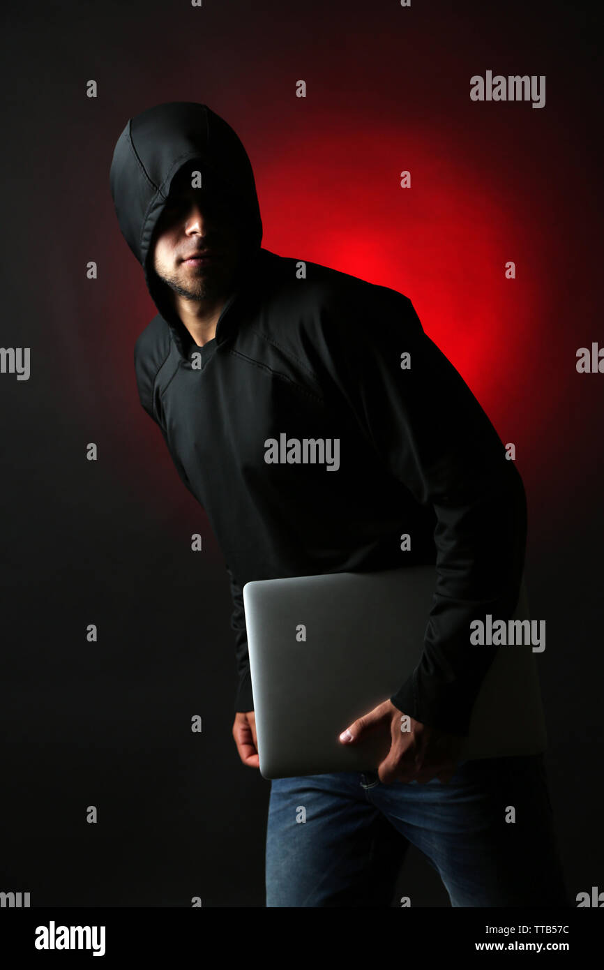 Hacker with computer and laptop on colorful dark background Stock Photo ...