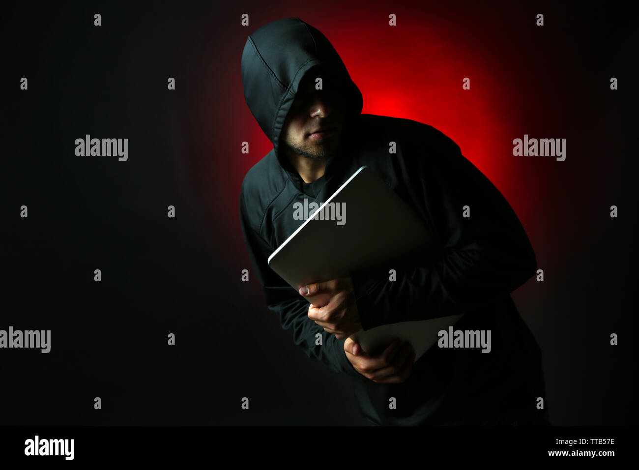 Hacker with computer and laptop on colorful dark background Stock Photo ...
