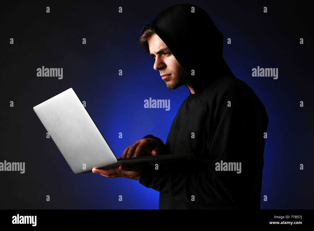 Hacker with computer and laptop on colorful dark background Stock Photo ...