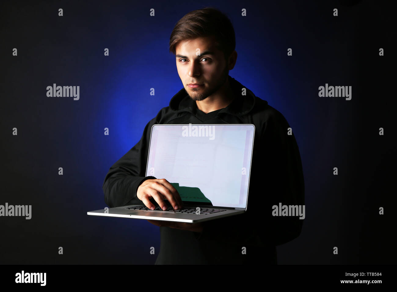 Hacker with computer and laptop on colorful dark background Stock Photo ...