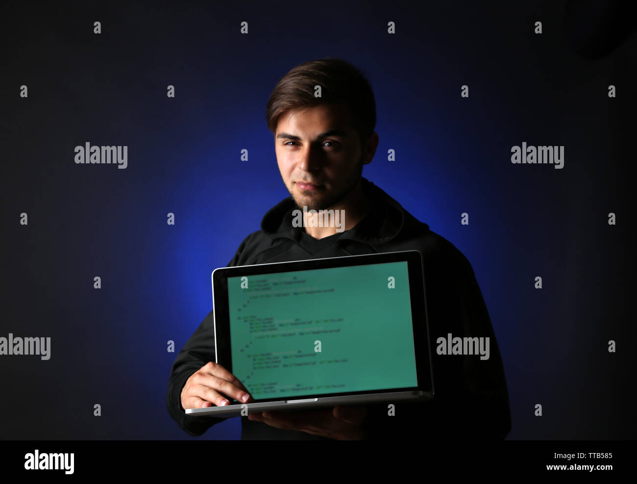 Hacker with computer and laptop on colorful dark background Stock Photo ...
