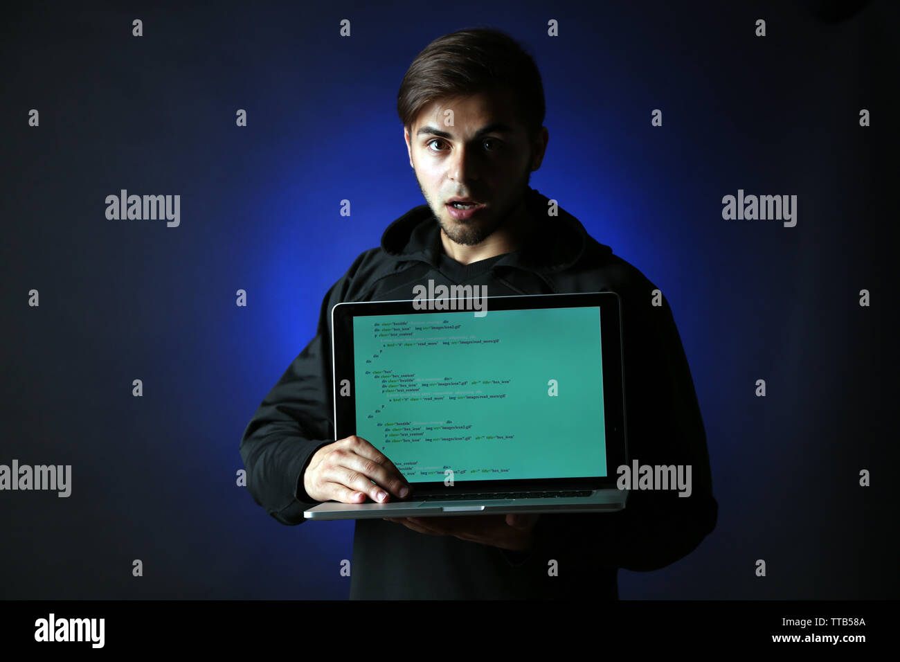 Hacker with computer and laptop on colorful dark background Stock Photo ...
