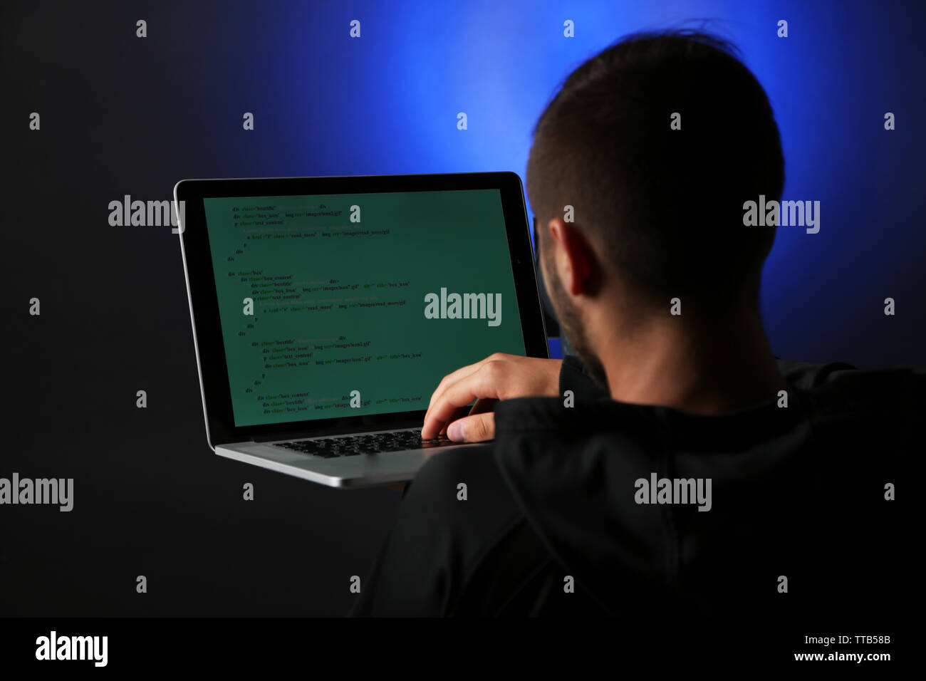 Hacker with computer and laptop on colorful dark background Stock Photo ...
