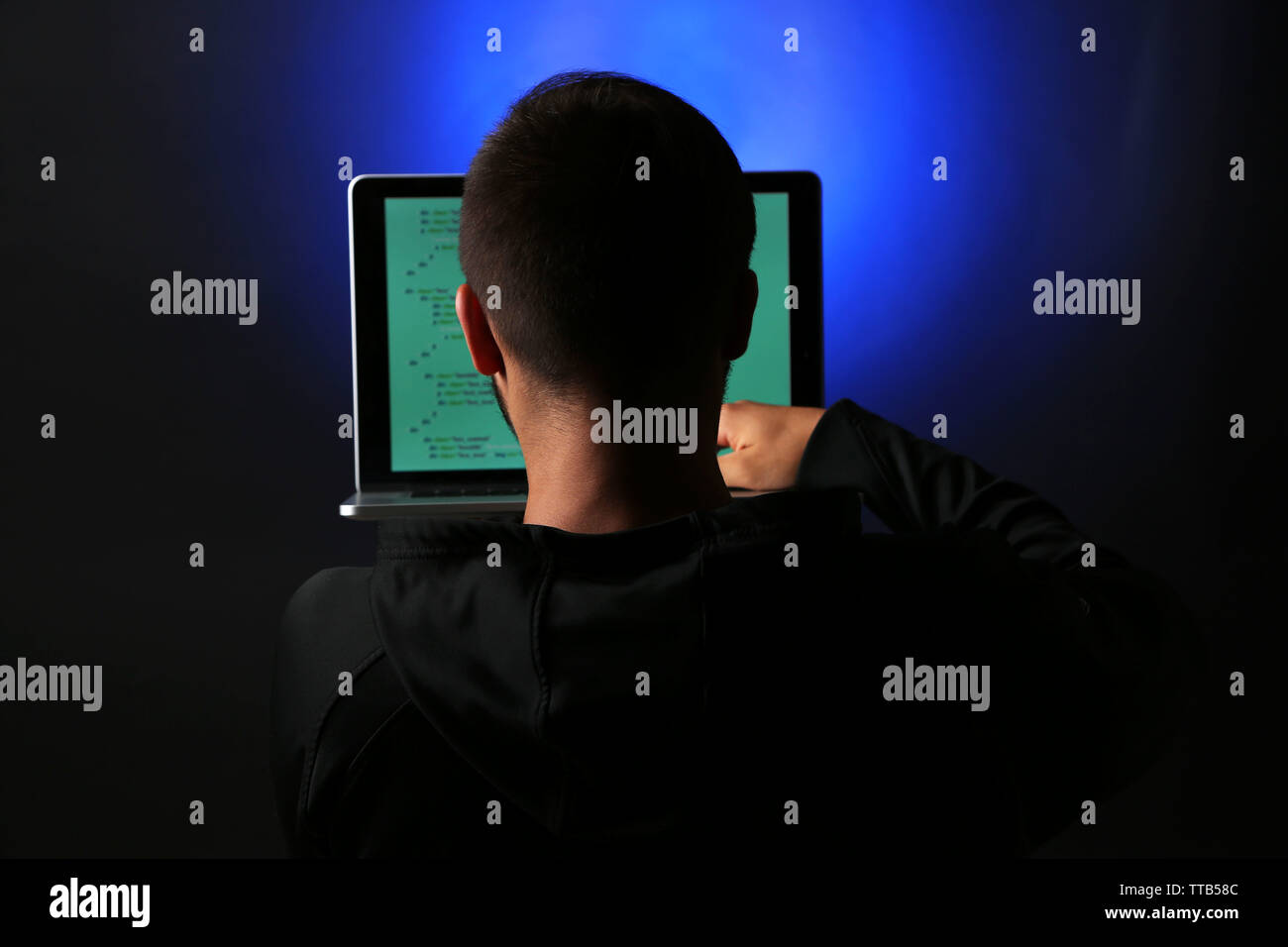 Hacker with computer and laptop on colorful dark background Stock Photo ...