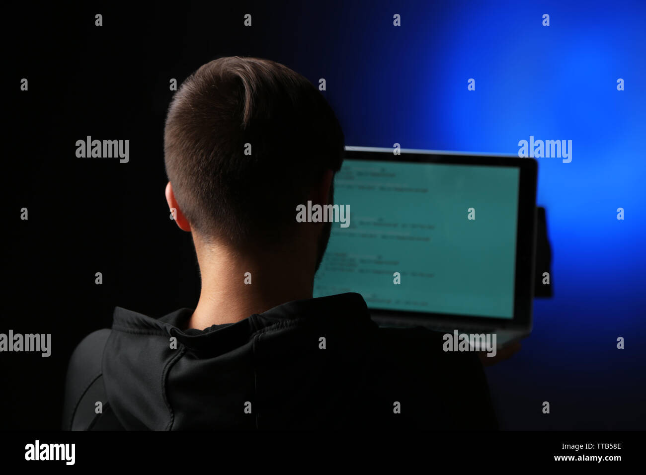 Hacker with computer and laptop on colorful dark background Stock Photo ...