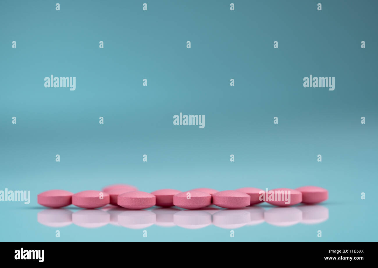 Round pink tablets pill on gradient background. Vitamins and minerals ...