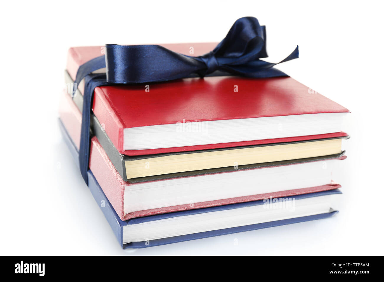 Stack of books with ribbon isolated on white Stock Photo - Alamy