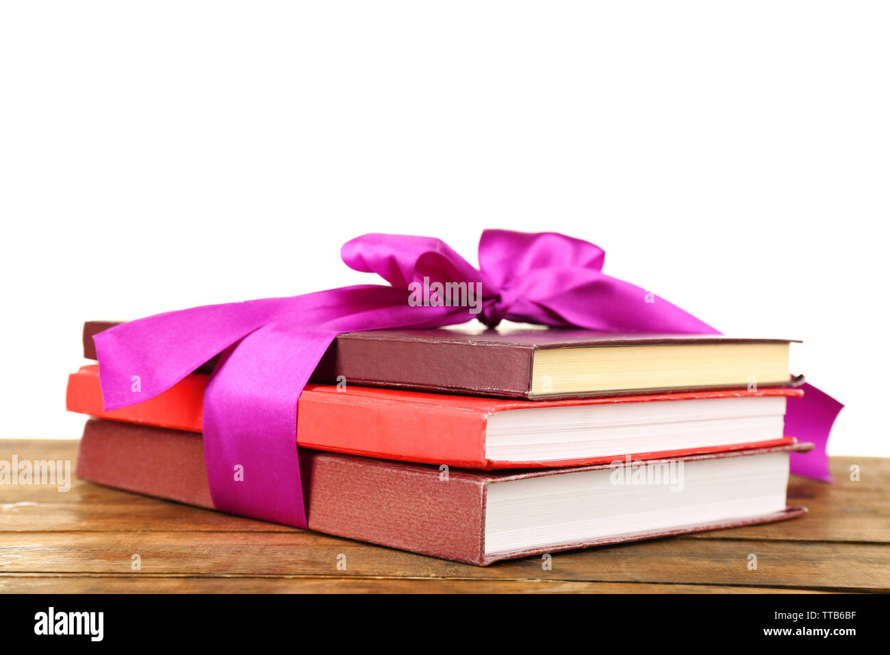 Stack of books with ribbon on table isolated on white Stock Photo - Alamy