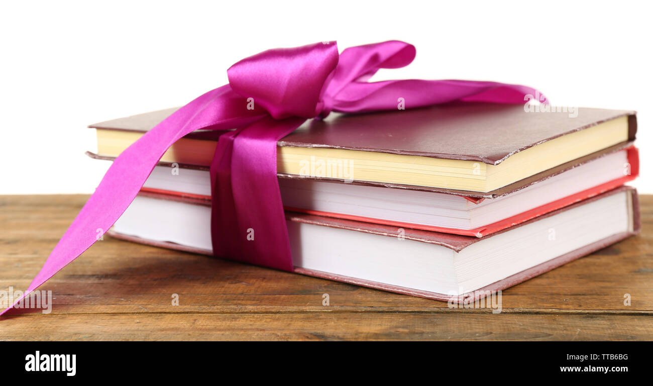 Stack of books with ribbon on table isolated on white Stock Photo - Alamy