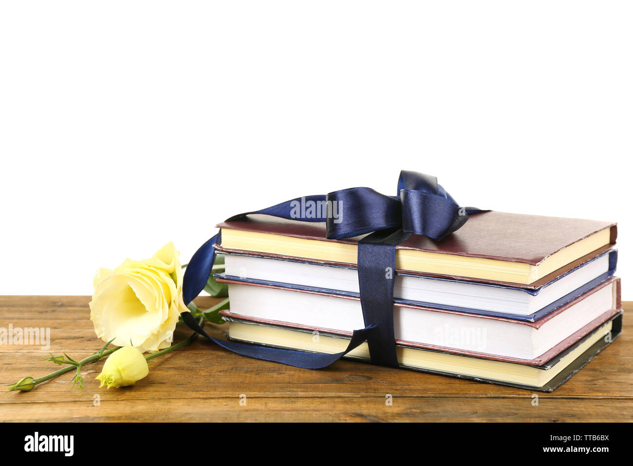 Stack of books with ribbon and flowers isolated on white Stock Photo ...