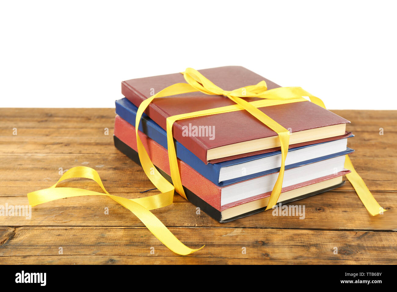 Stack of books with ribbon on light background Stock Photo - Alamy