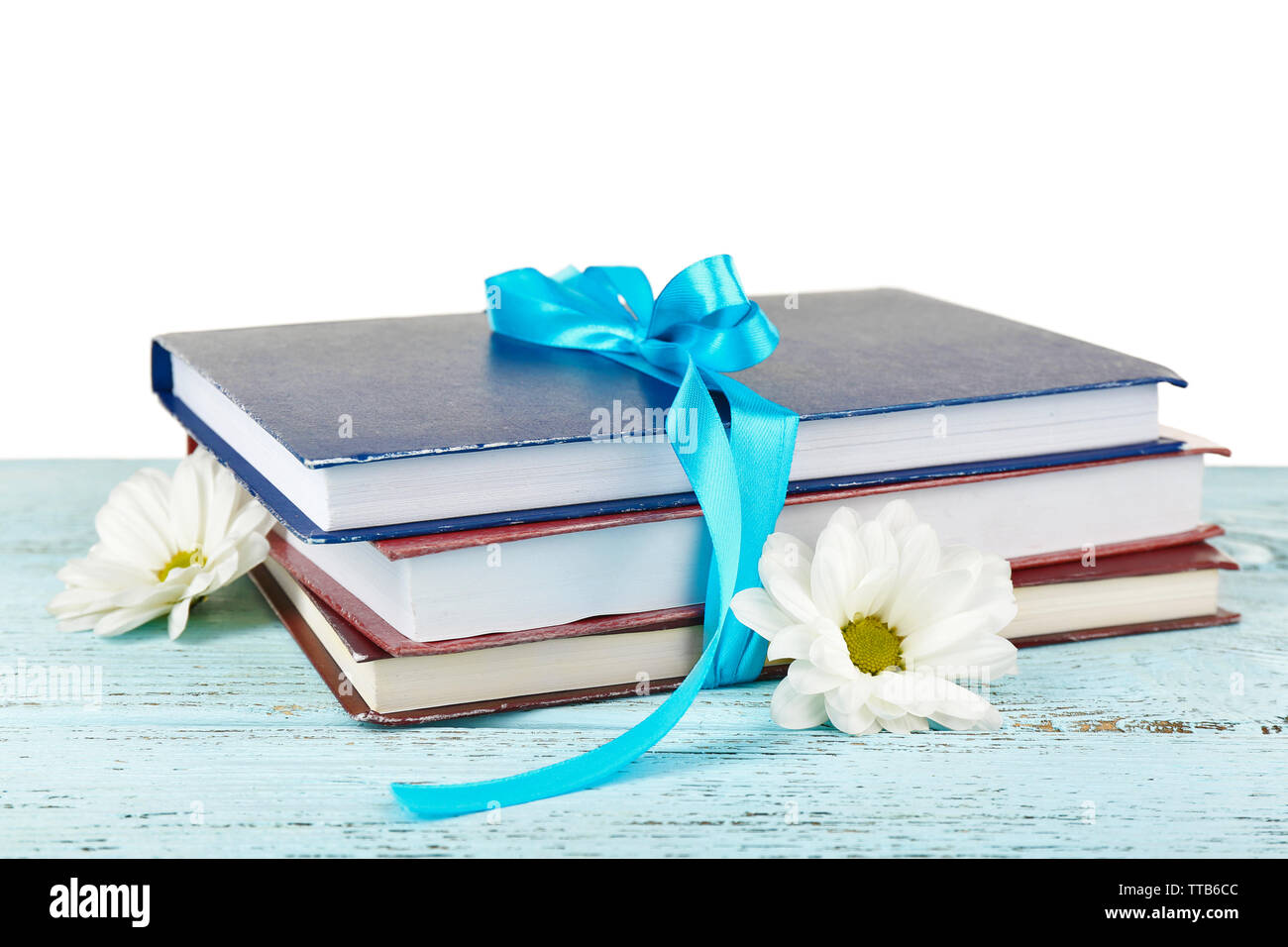 Stack of books with ribbon on table isolated on white Stock Photo - Alamy