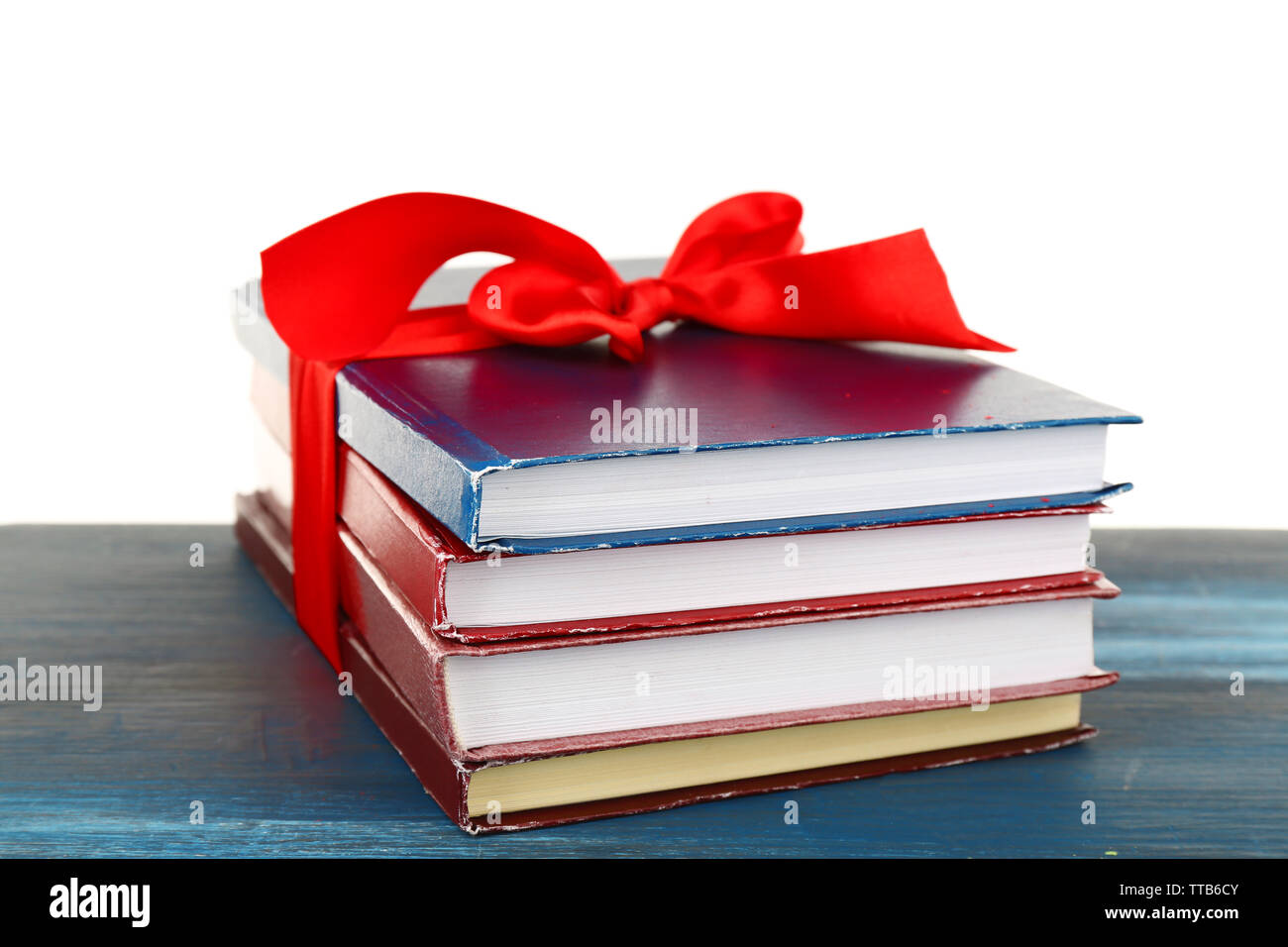 Stack of books with ribbon on light background Stock Photo - Alamy