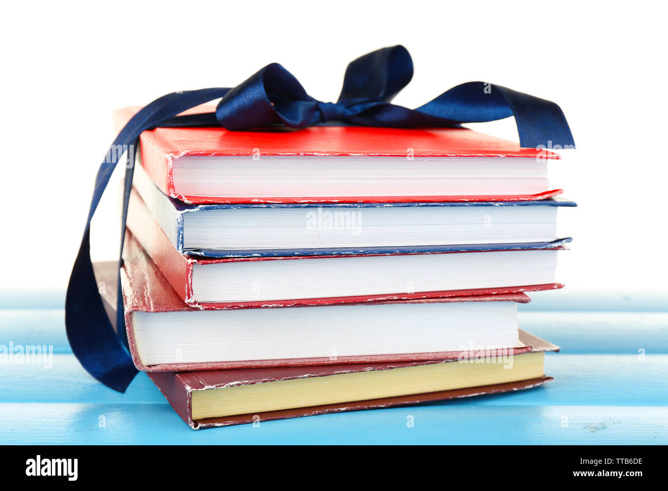 Stack of books with ribbon on light background Stock Photo - Alamy