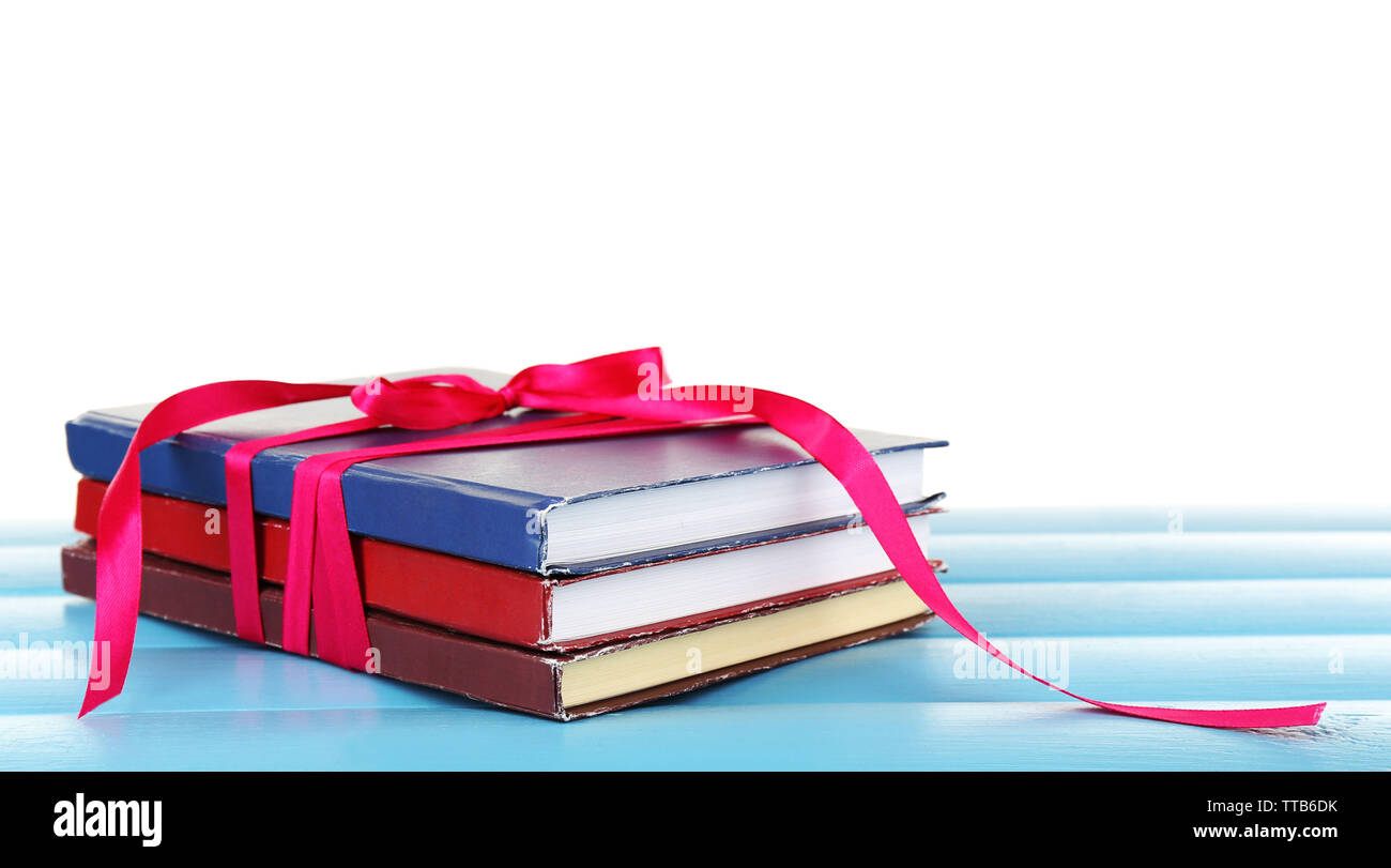 Stack of books with ribbon on table isolated on white Stock Photo - Alamy