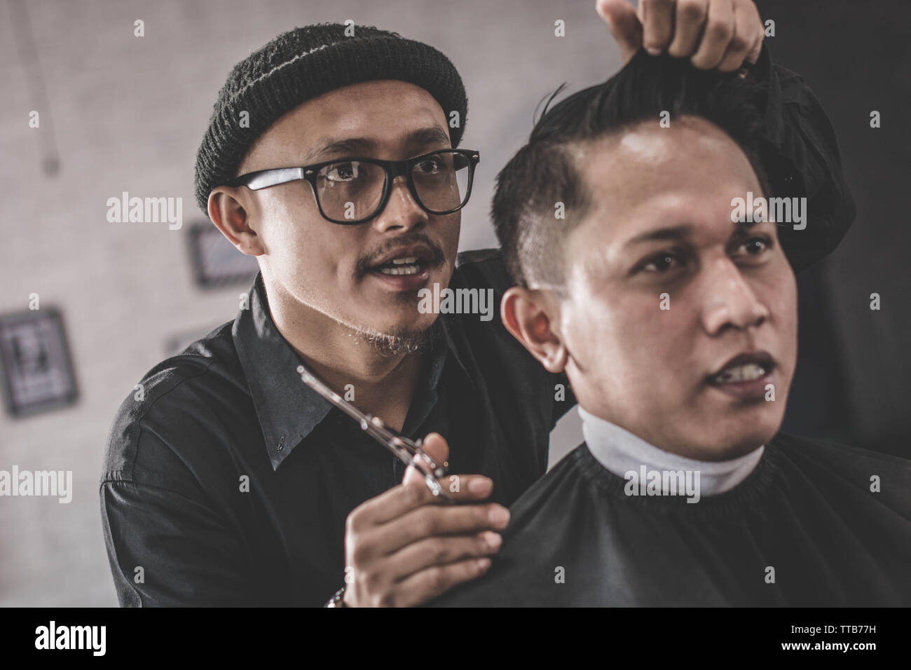 close up portrait of barber hairstyle styling hair of his costumer hair ...