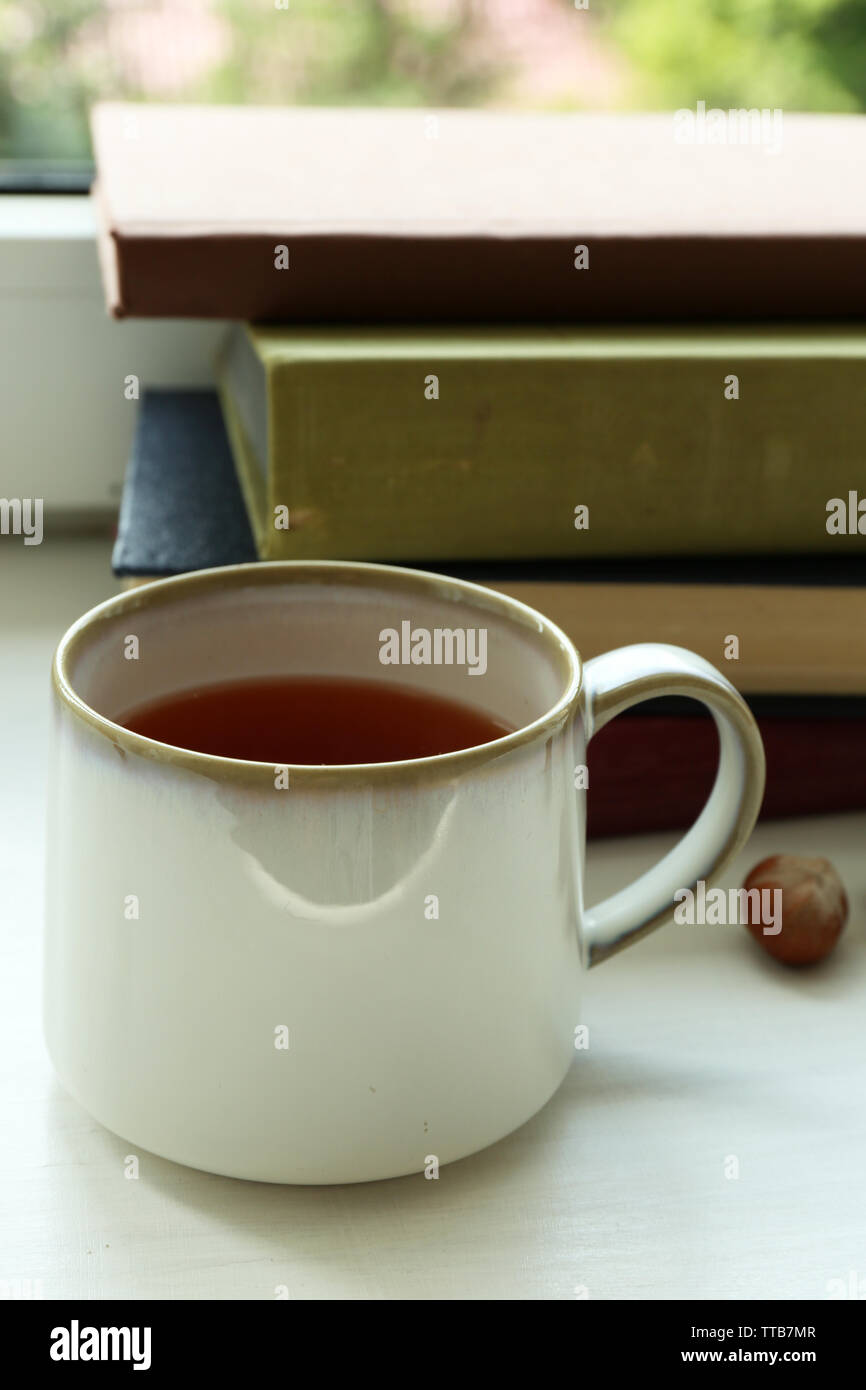 Cup of tea with stack of books on windowsill, closeup Stock Photo - Alamy