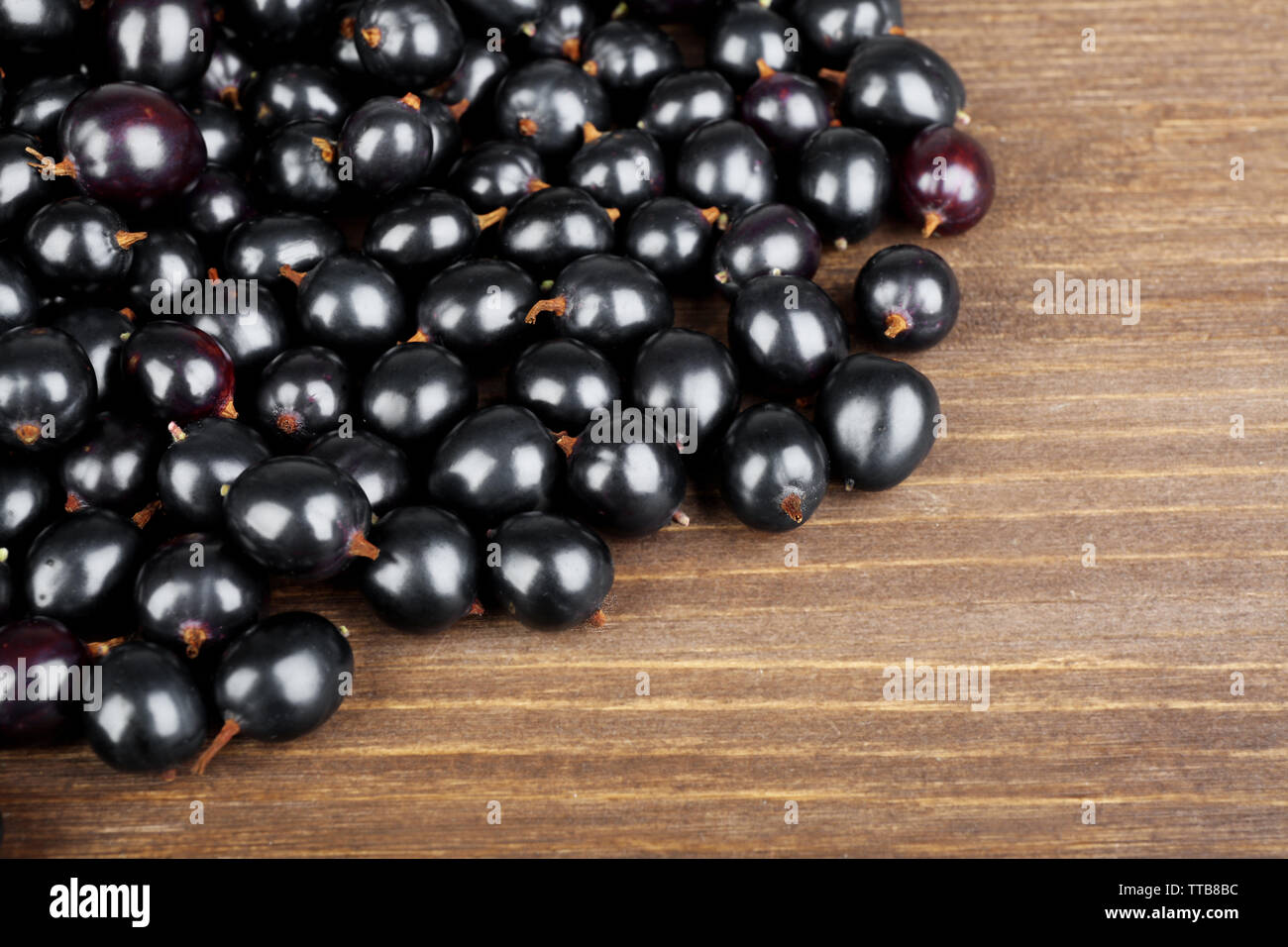 Heap of wild black currant on wooden table close up Stock Photo - Alamy