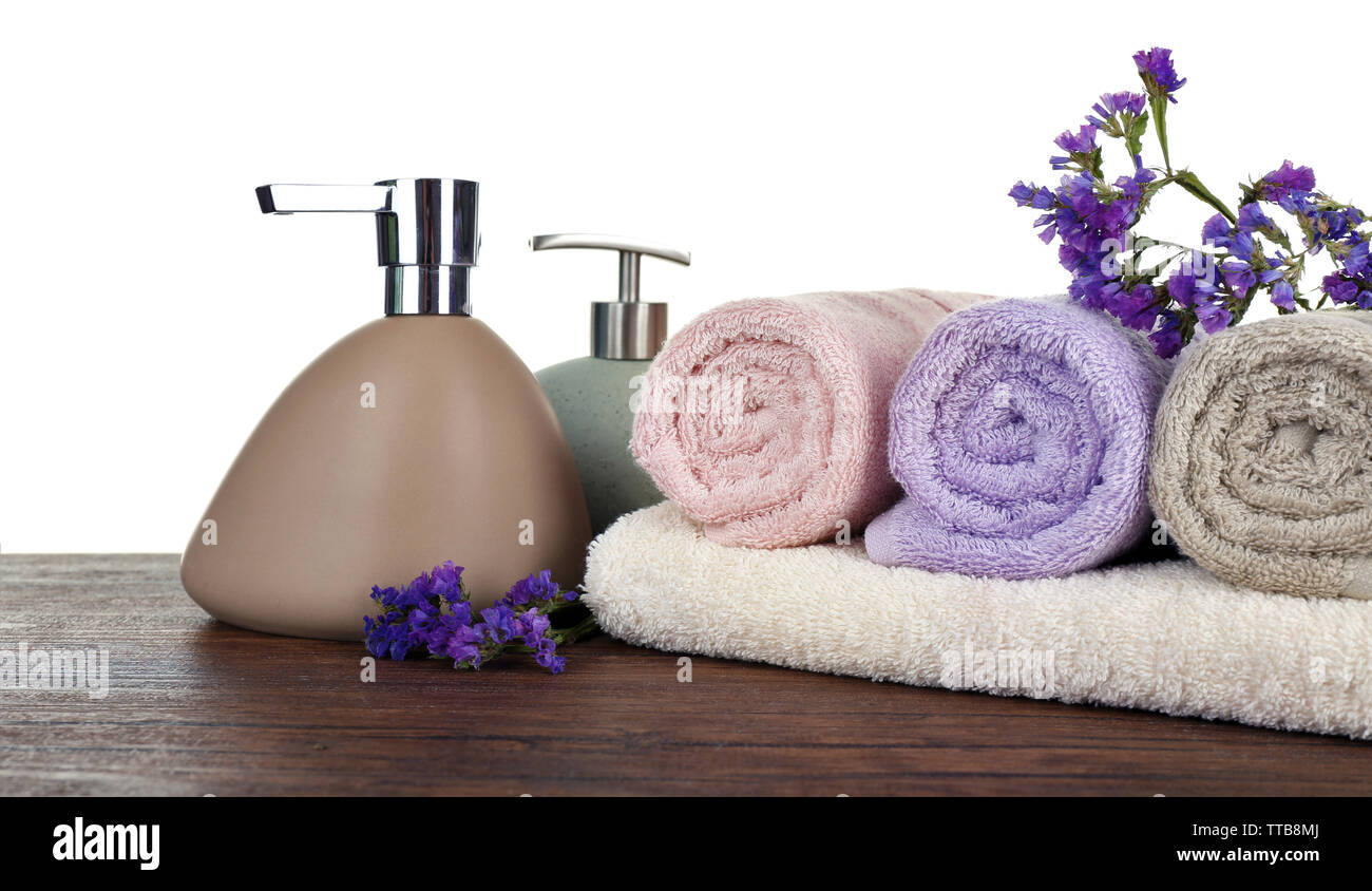 Soft towels with dispenser and flowers on light background Stock Photo ...