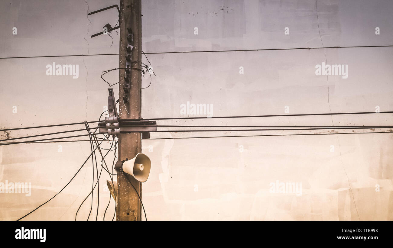 A line of electric communication facilities poles over white wall ...