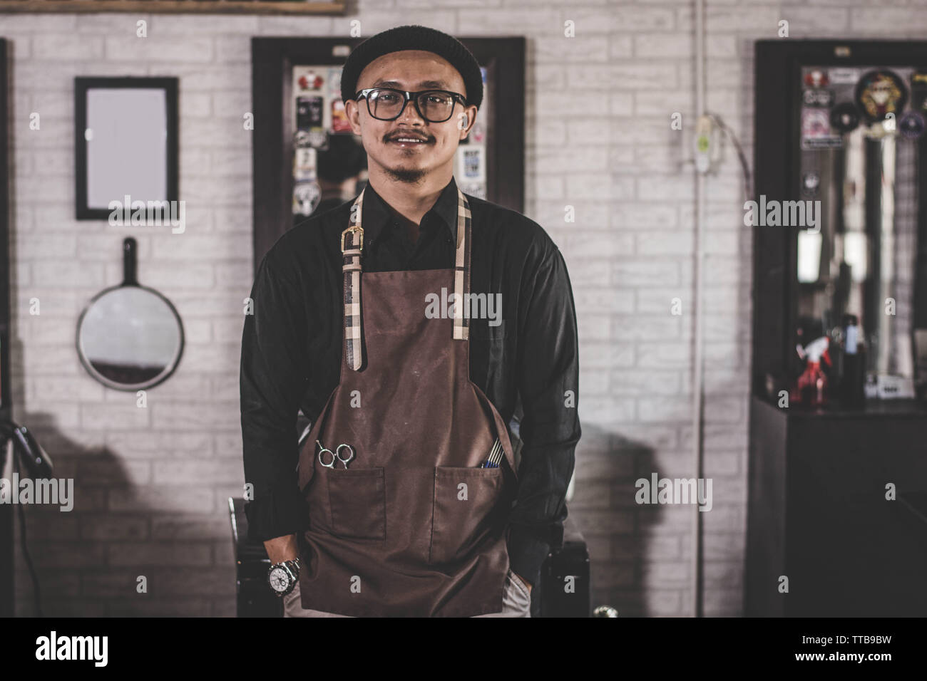 portrait of happy Barber man hairstylist posing and standing with apron ...