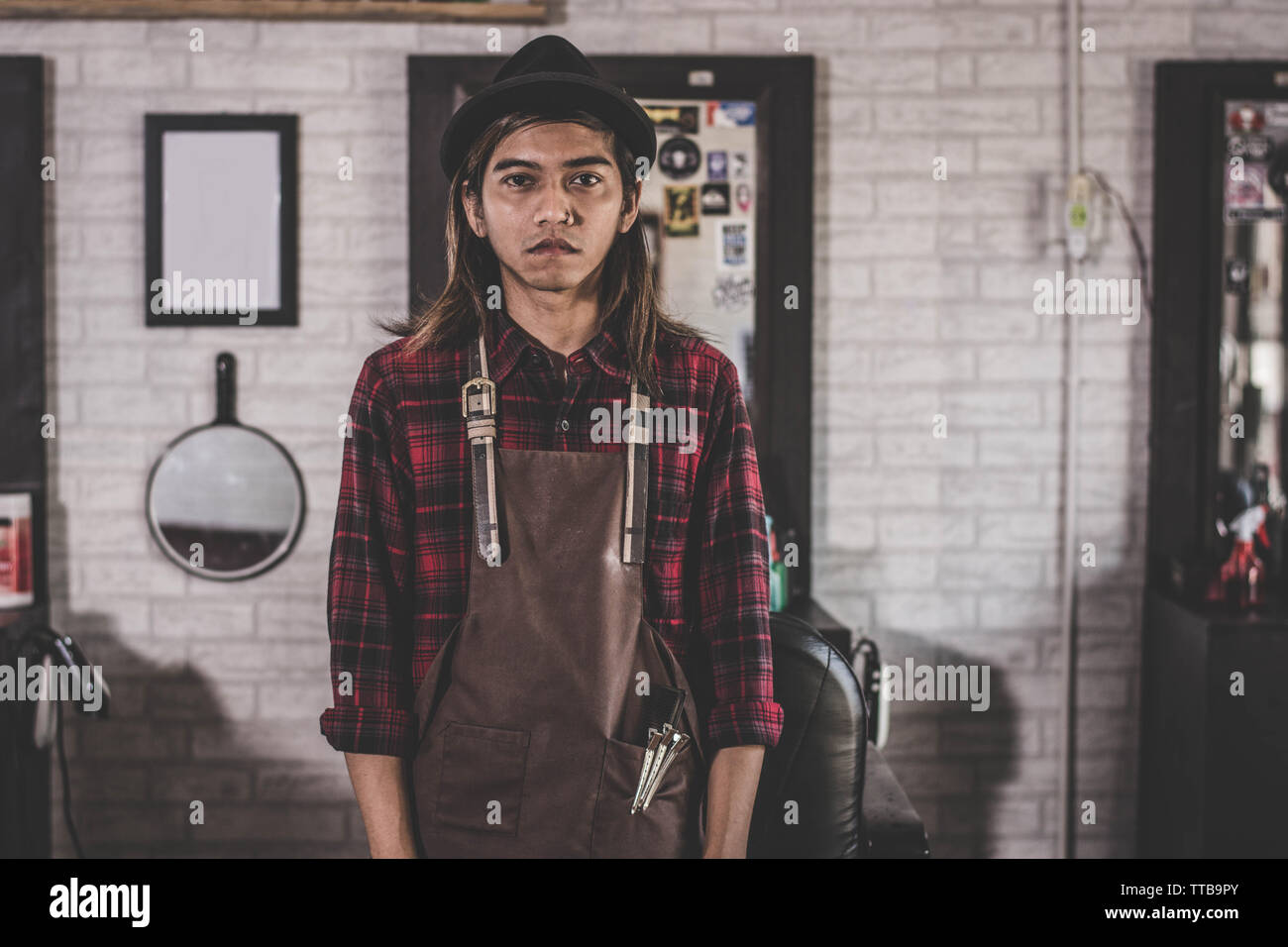 portrait of fashionable barber man hairstylist posing and standing with ...