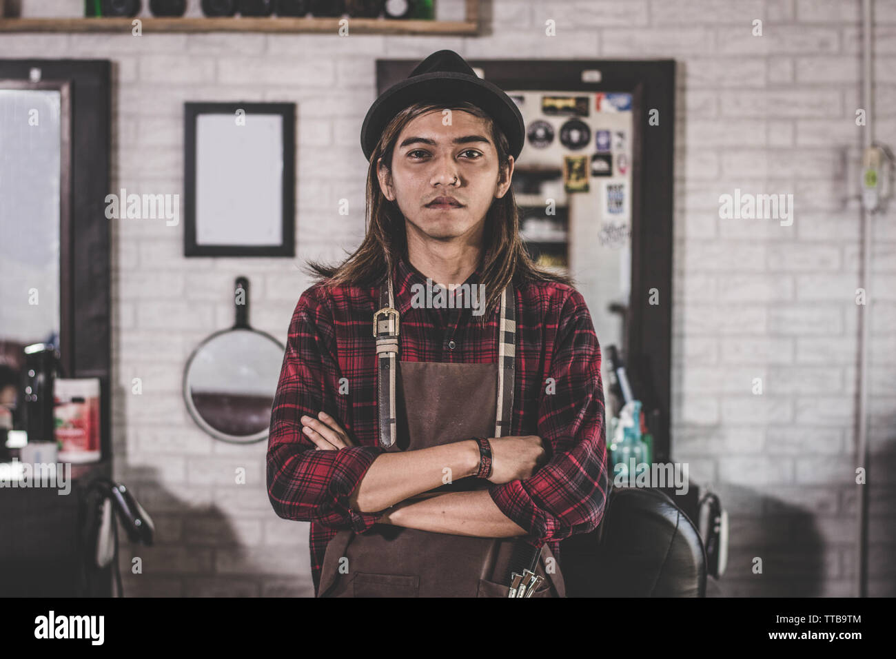 portrait of fashionable barber man hairstylist posing and standing with ...