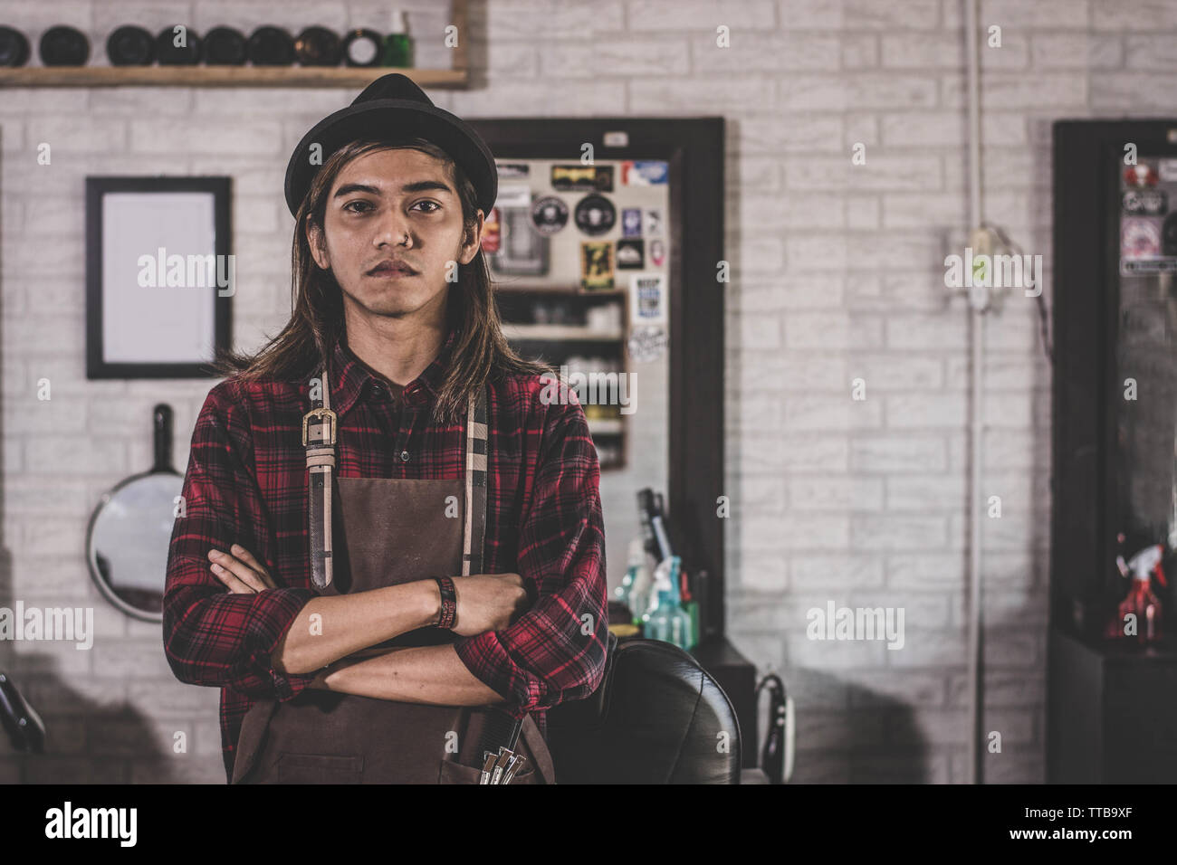 portrait of fashionable barber man hairstylist posing and standing with ...