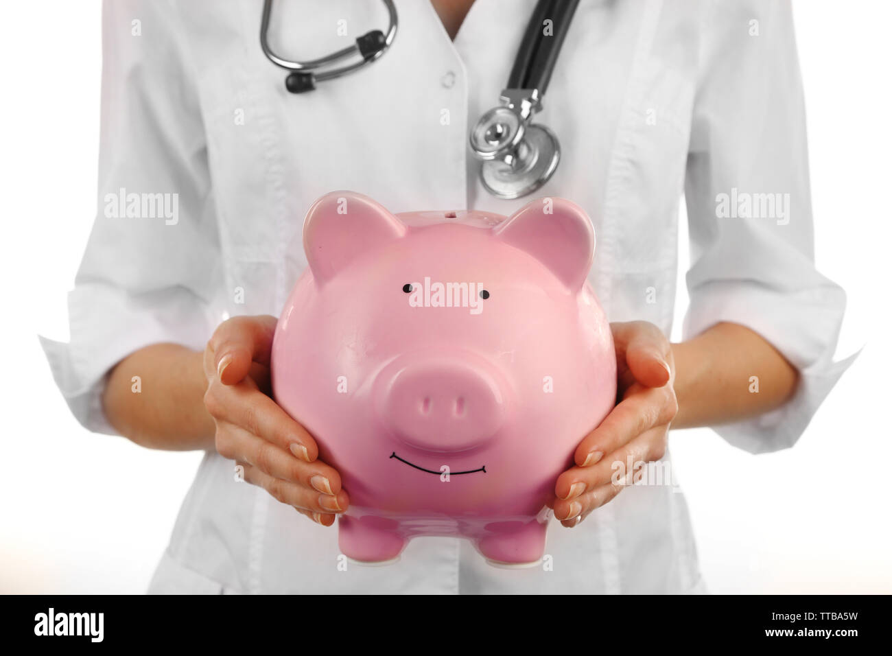 Doctor in white uniform with stethoscope holding pink piggy bank ...