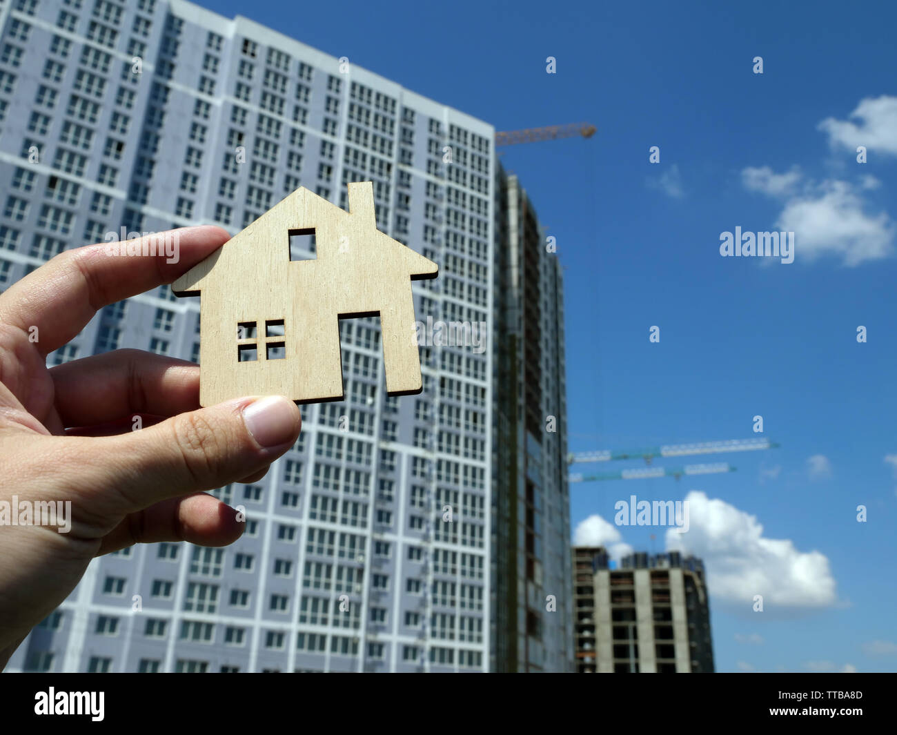 Hand holding symbol of property ownership in front of building Stock ...