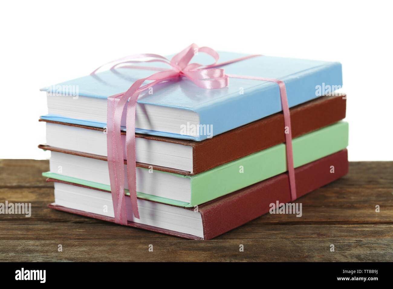 Stack of books with ribbon on light background Stock Photo - Alamy